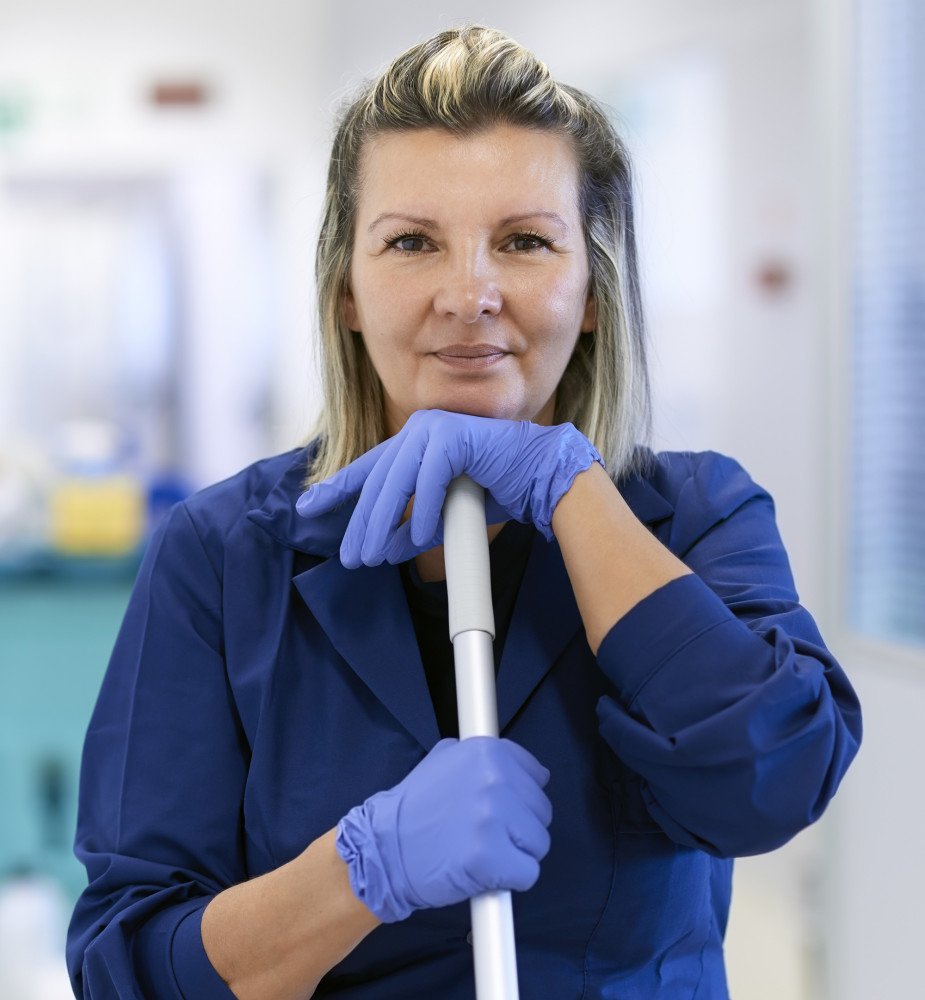 Portrait of happy professional female cleaner smiling in office ...